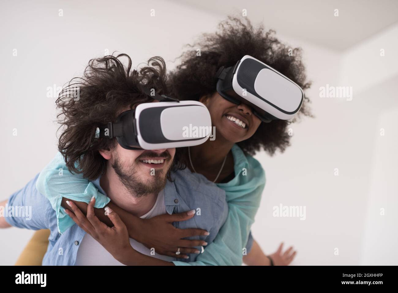 Happy multiethnic couple getting experience using VR headset glasses of ...