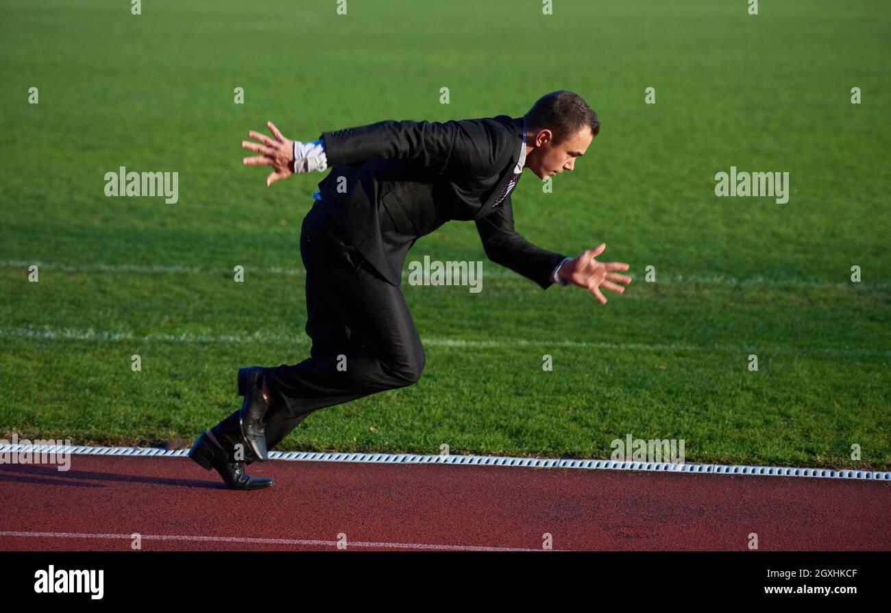 business man in start position ready to run and sprint on athletics ...