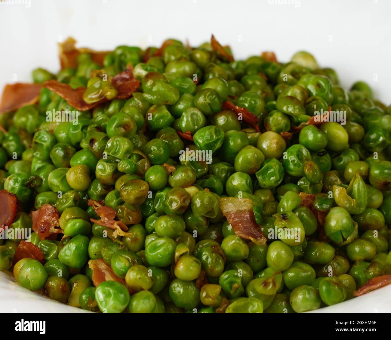 Peas with ham in a white dish. Close up view Stock Photo - Alamy