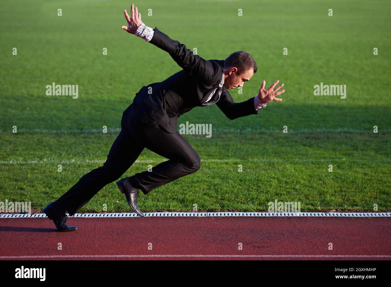 business man in start position ready to run and sprint on athletics ...