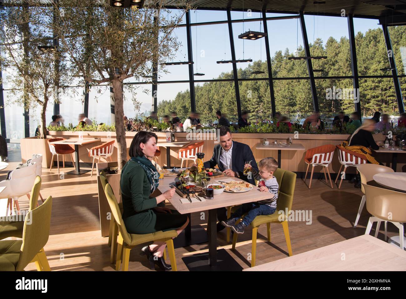 Young parents enjoying lunch time with their children at a luxury ...