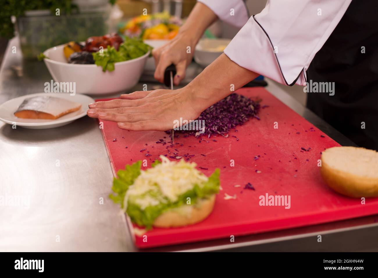 master chef cutting salad for a burger in the rastaurant kitchen Stock ...