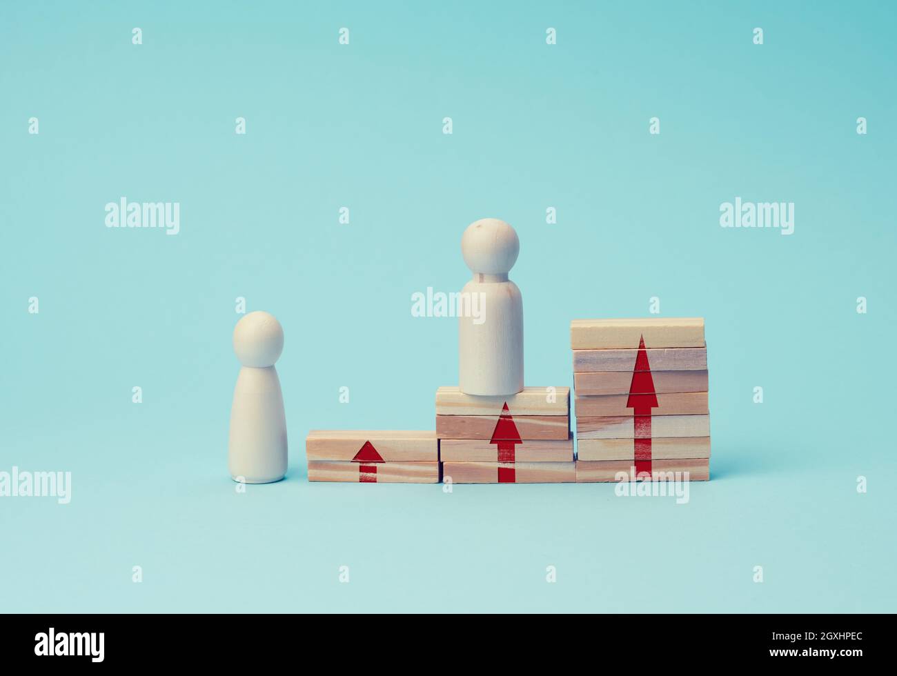 wooden figurine of a man at the top of the pyramid. The concept of ...