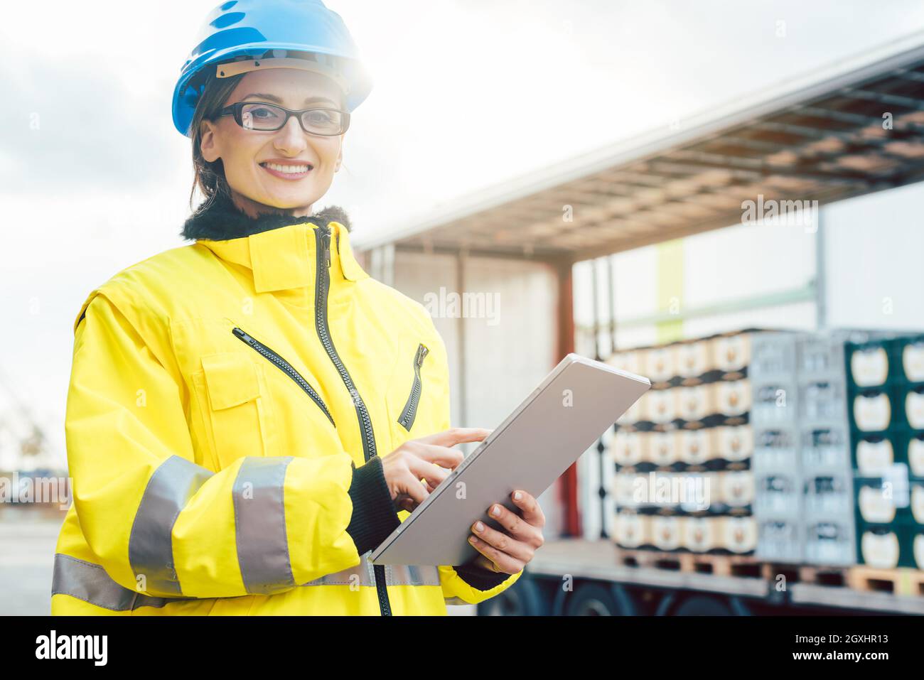 Supervisor checking contents of shipment to be sent by truck on her ...