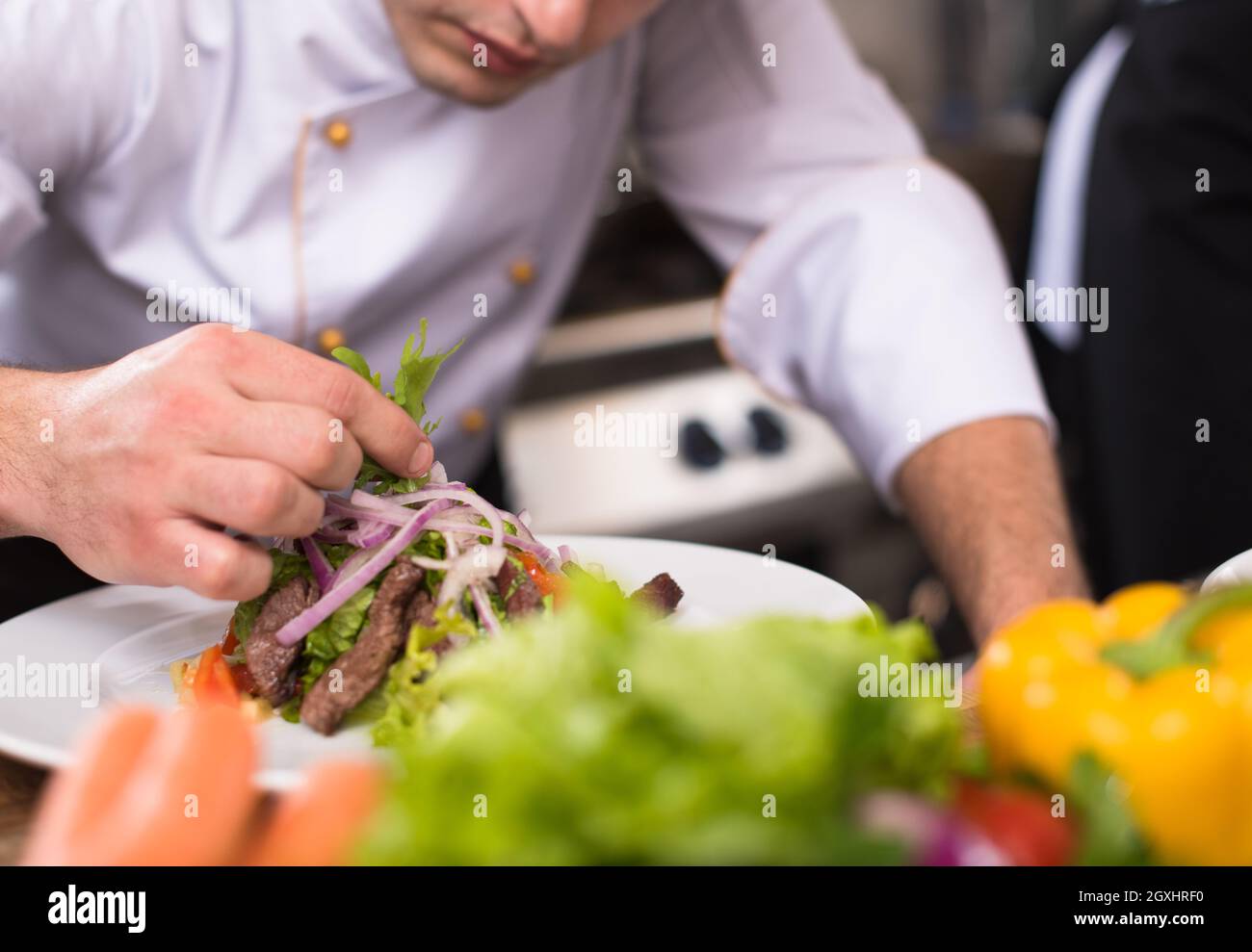 cook chef decorating garnishing prepared meal dish on the plate in ...