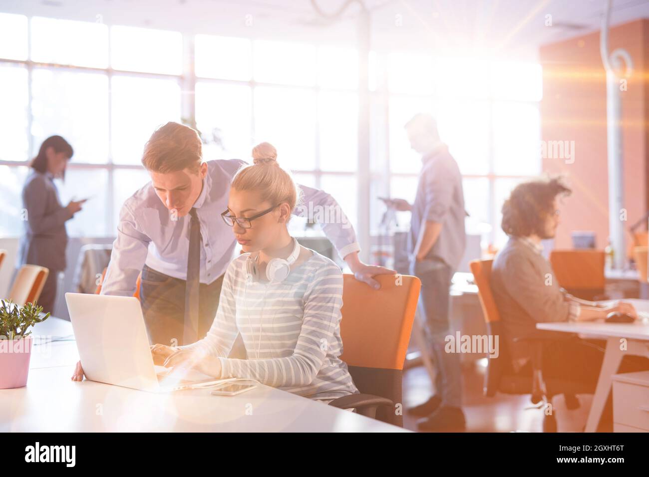 Young businessman helping his colleague to fix the problem at the work ...