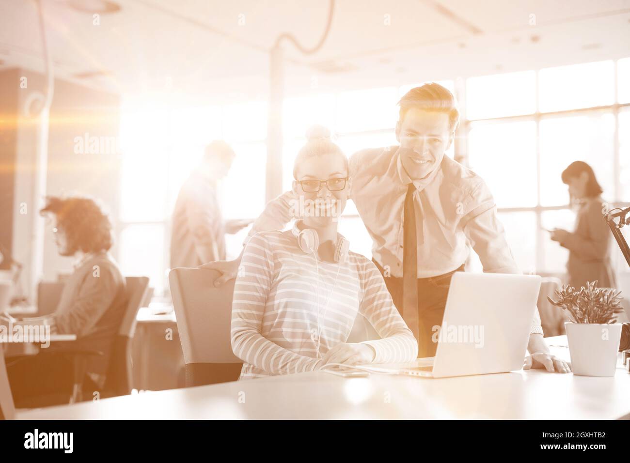 Young businessman helping his colleague to fix the problem at the work ...