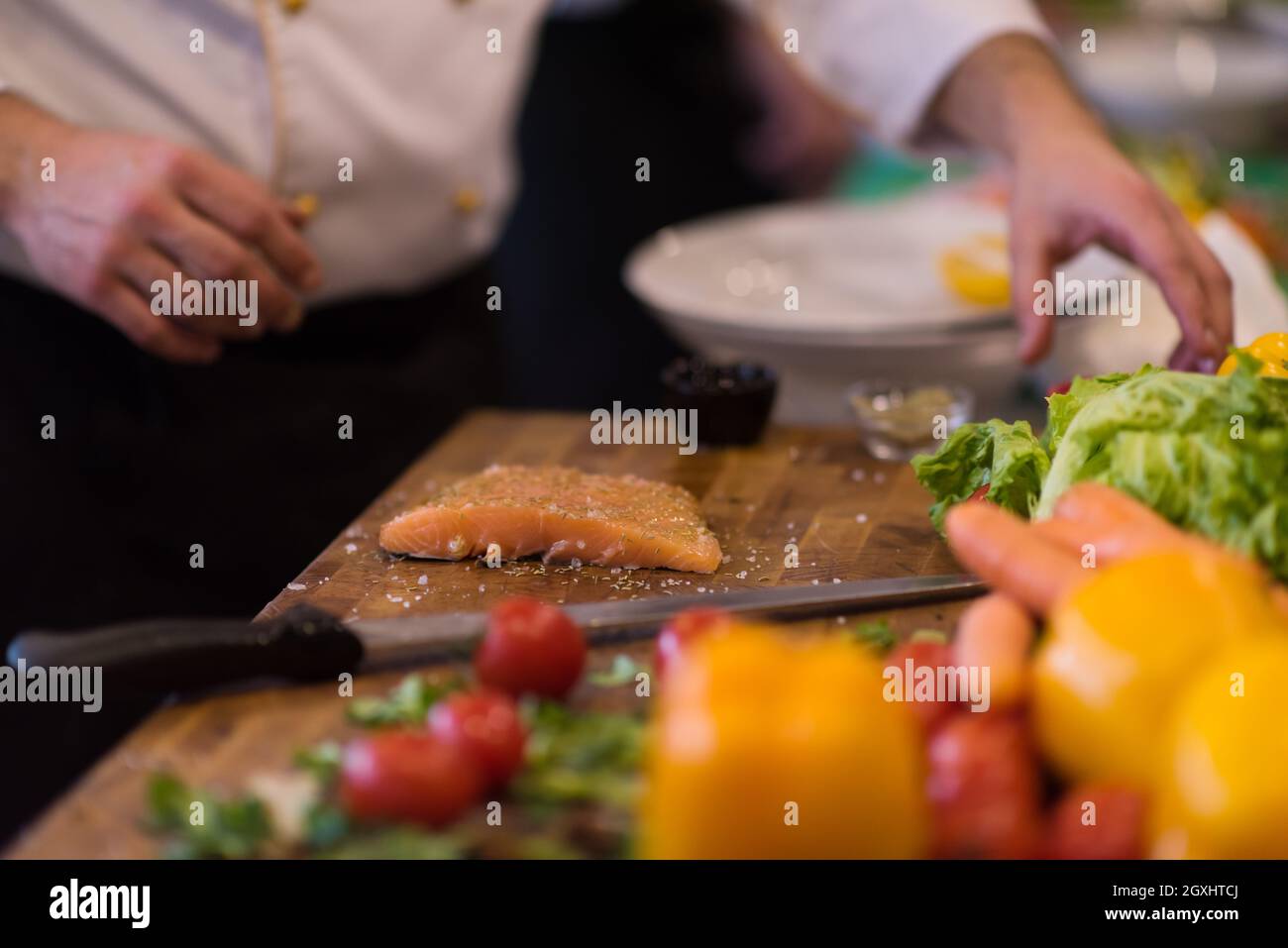 Chef hands preparing marinated Salmon fish fillet for frying in a ...