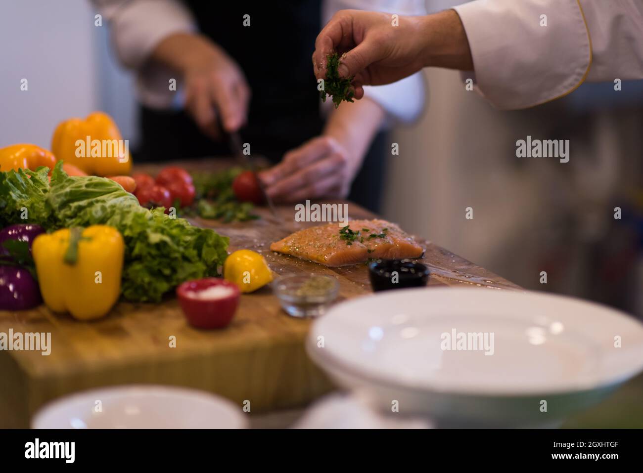 Chef hands preparing marinated Salmon fish fillet for frying in a ...