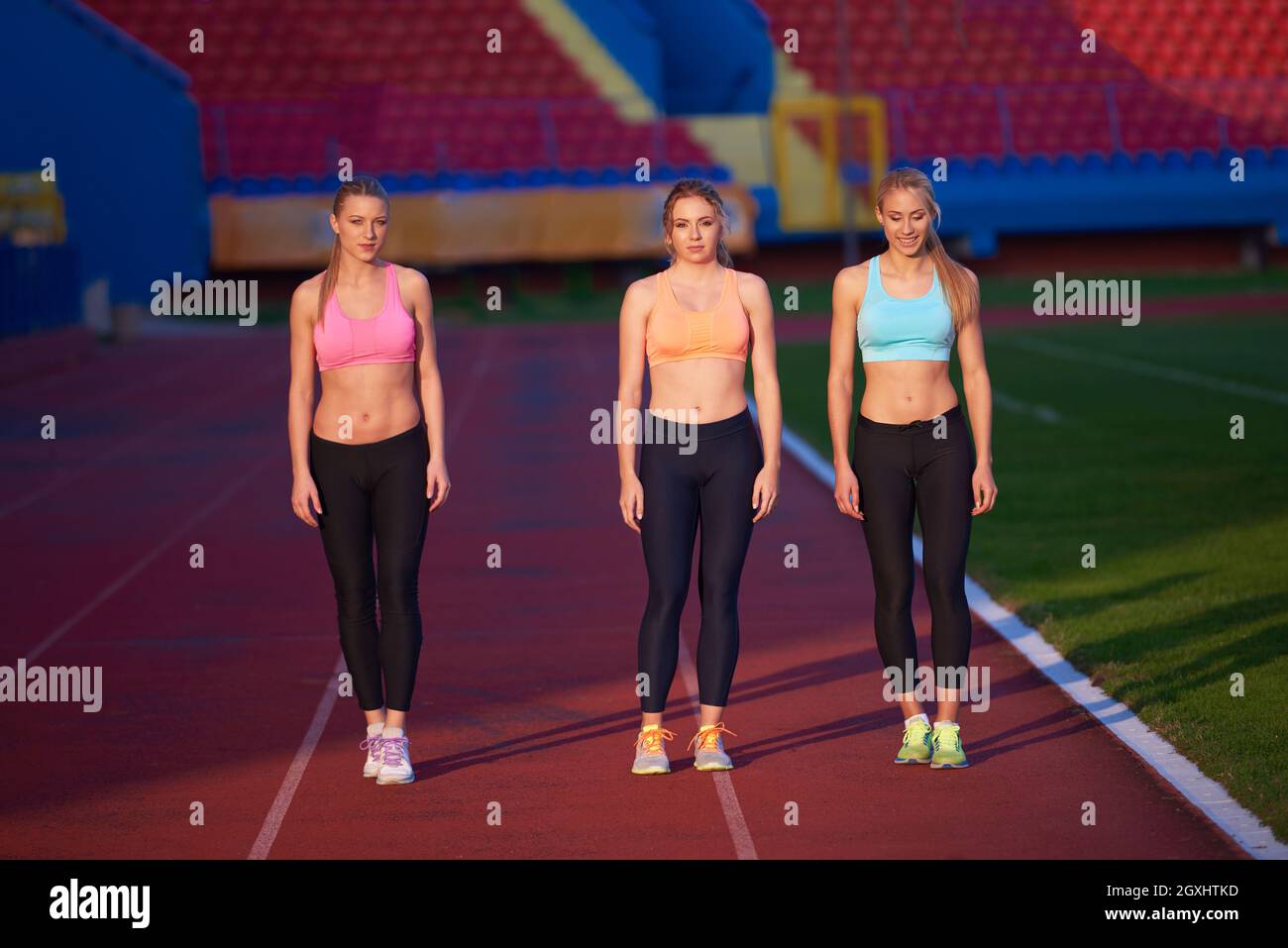athlete woman group running on athletics race track on soccer stadium ...