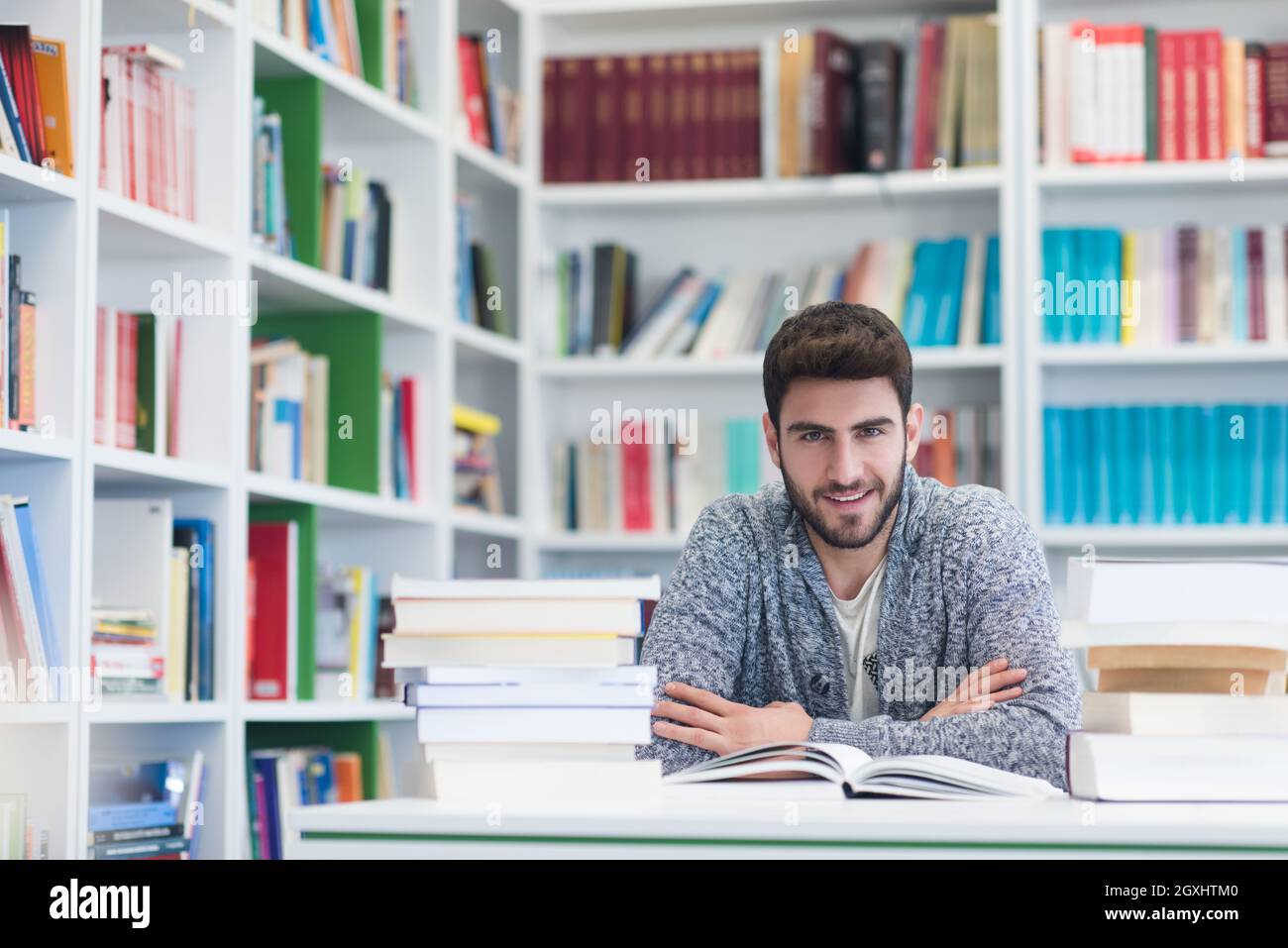 Portrait of happy student while reading book in school library. Study ...