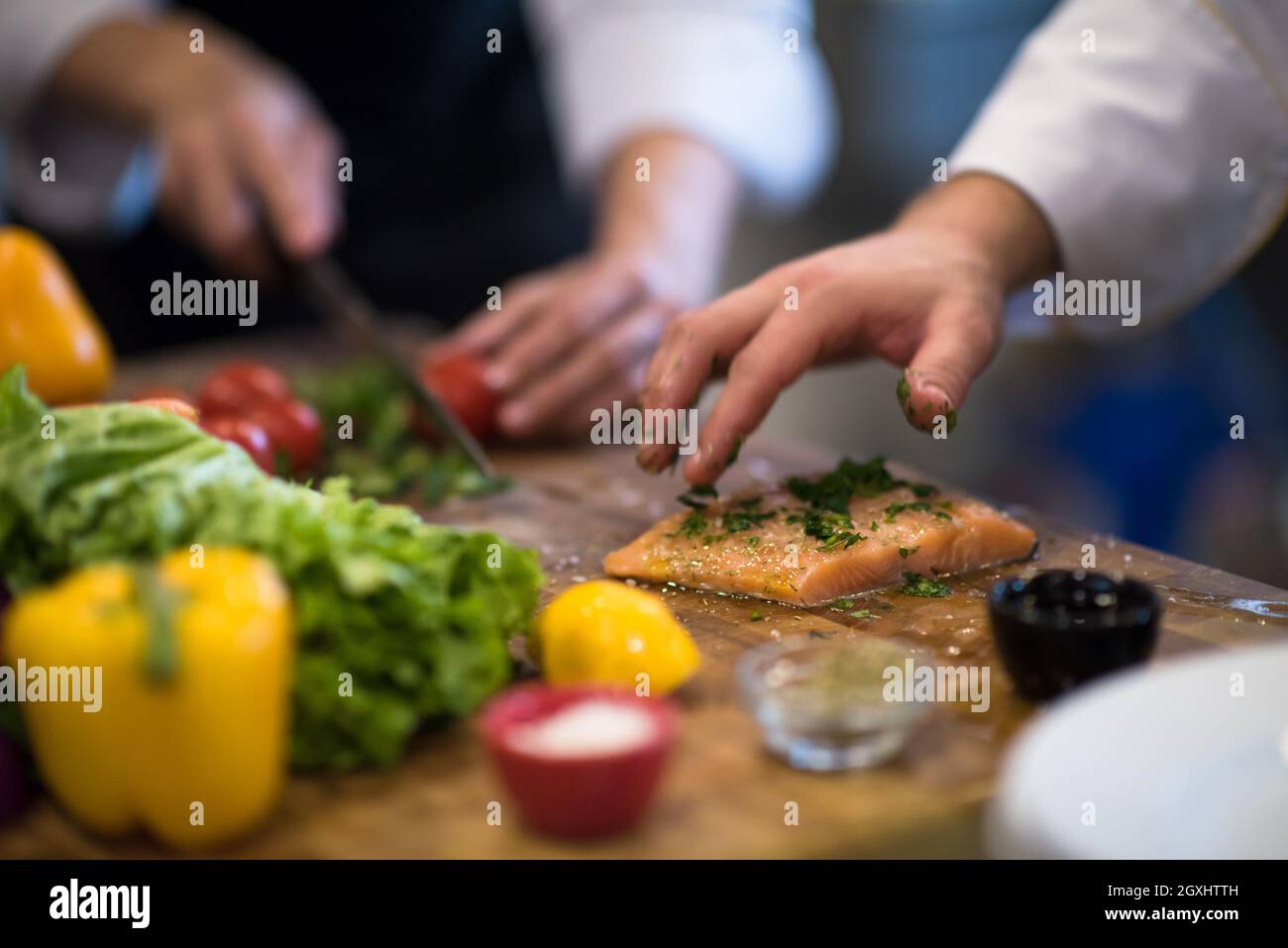 Chef hands preparing marinated Salmon fish fillet for frying in a ...