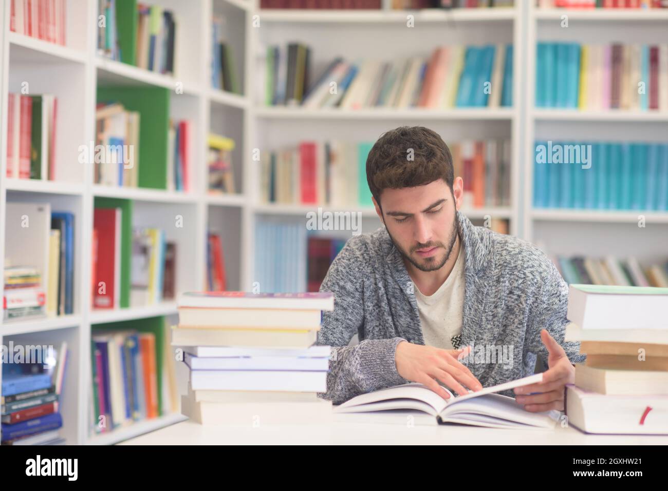 Portrait of happy student while reading book in school library. Study ...
