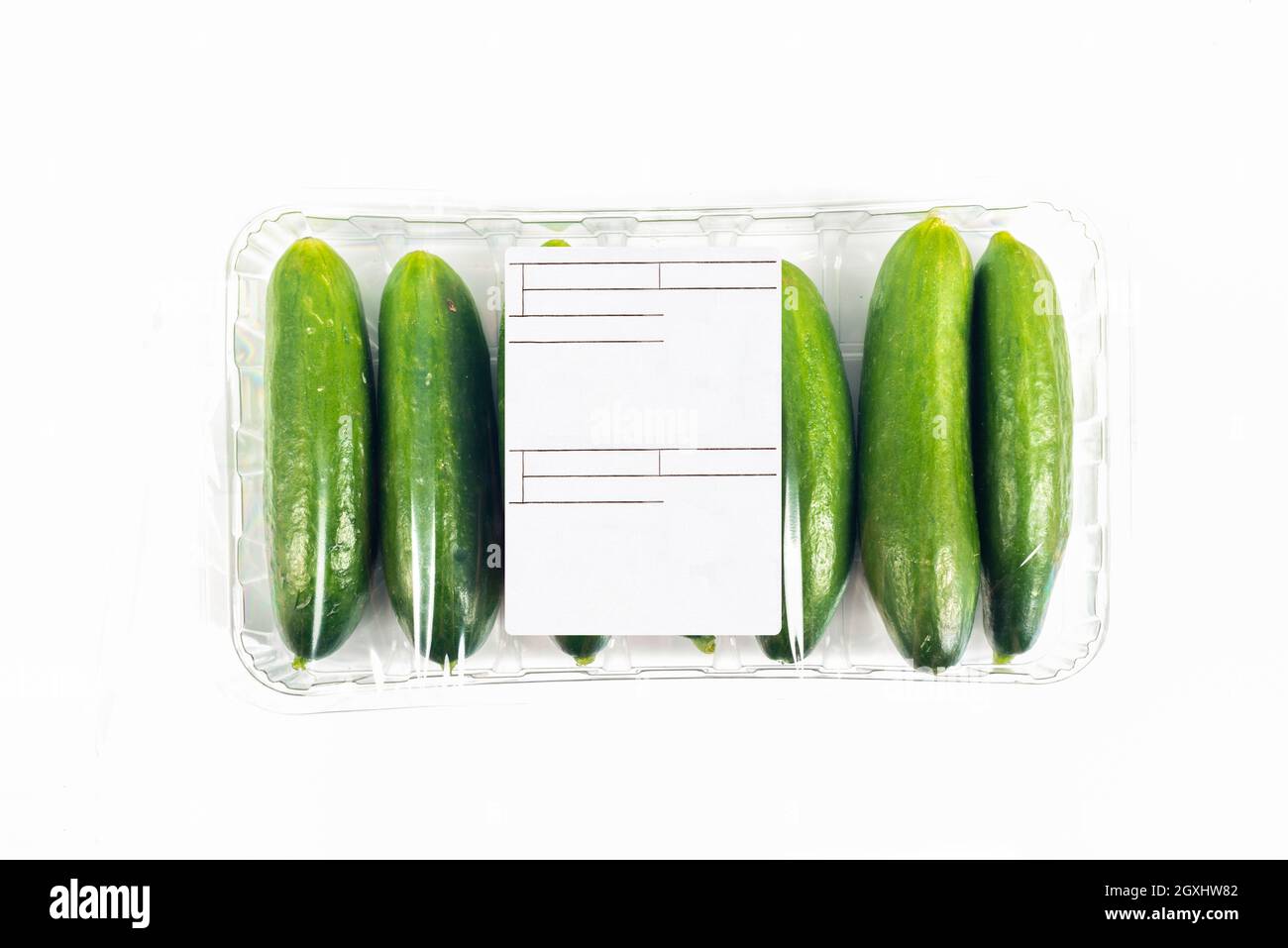 Freshly harvested mini cucumber with package and label on white ...