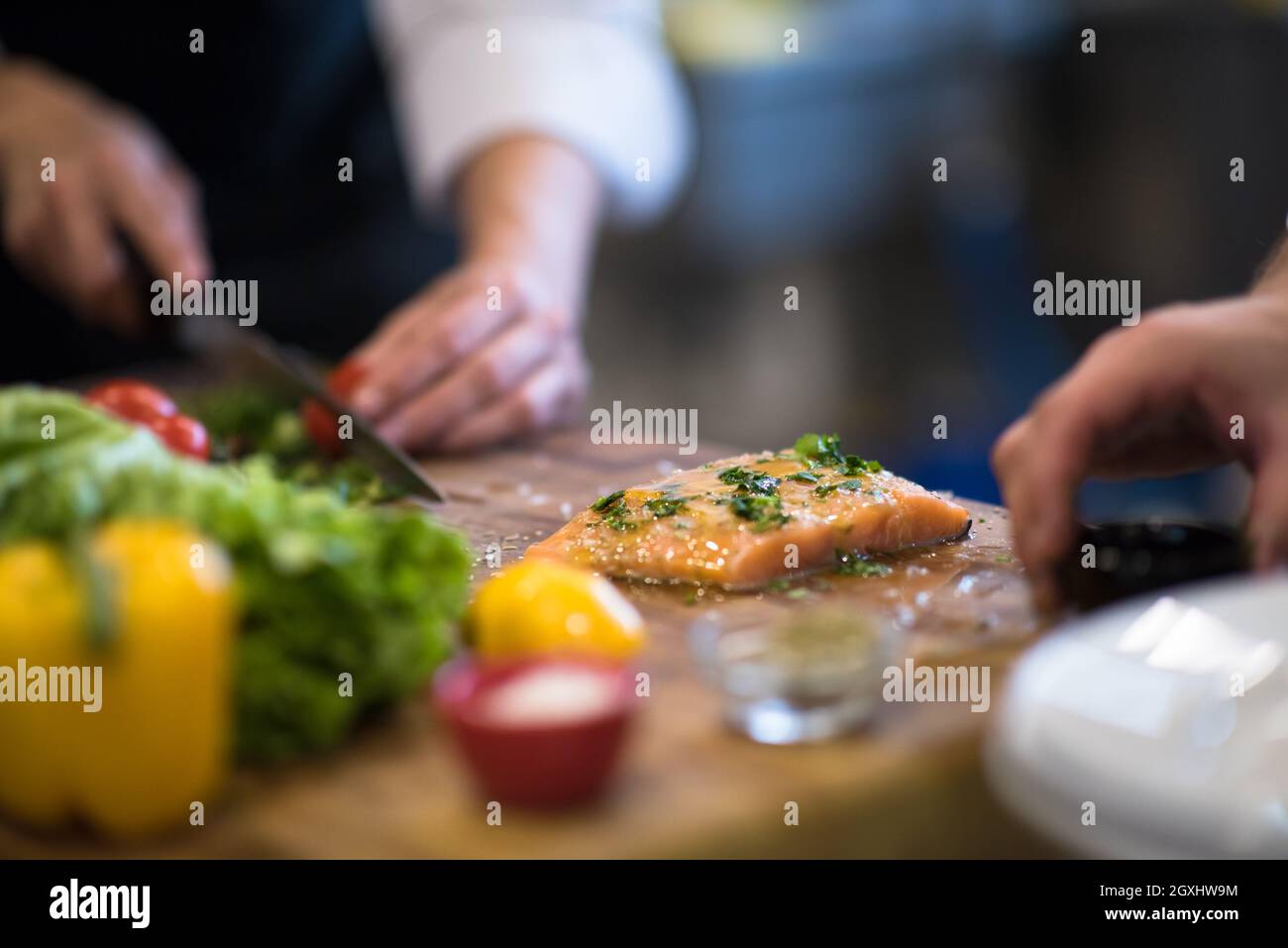 Chef hands preparing marinated Salmon fish fillet for frying in a ...