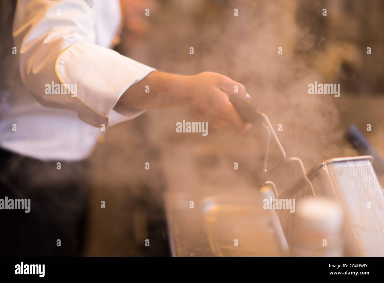 Master chef preparing food, frying in deep fryer. Sale and food concept ...