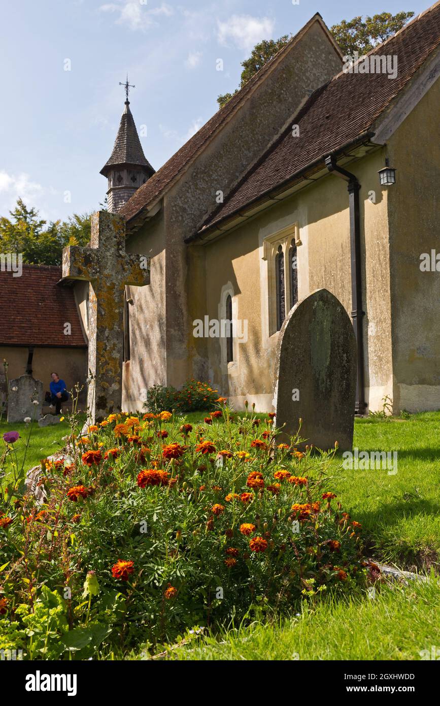 Flowers and gravestones in the graveyard in front of the 12th century ...