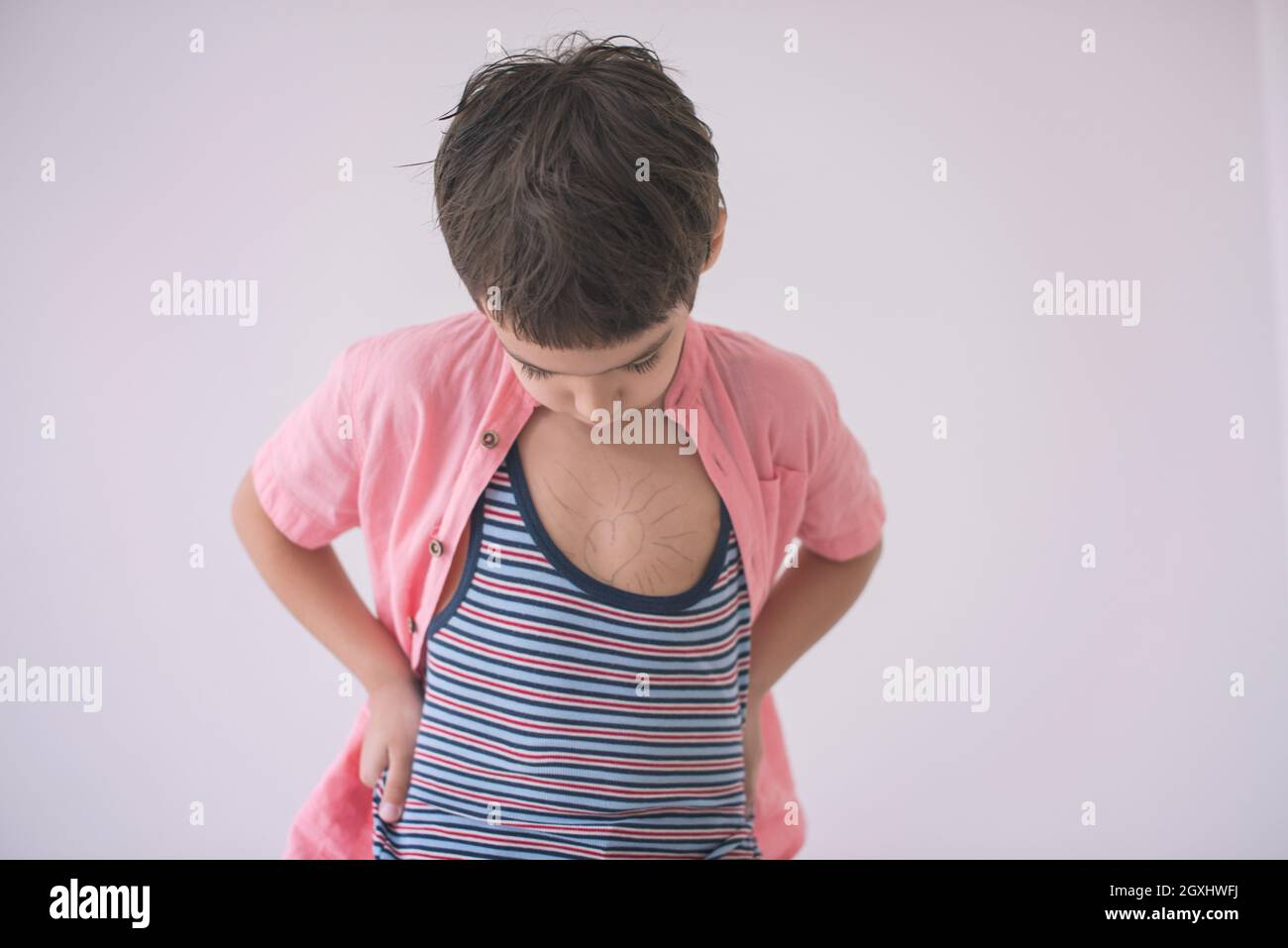 happy little boy looking at heart love symbol sketched on his chest ...