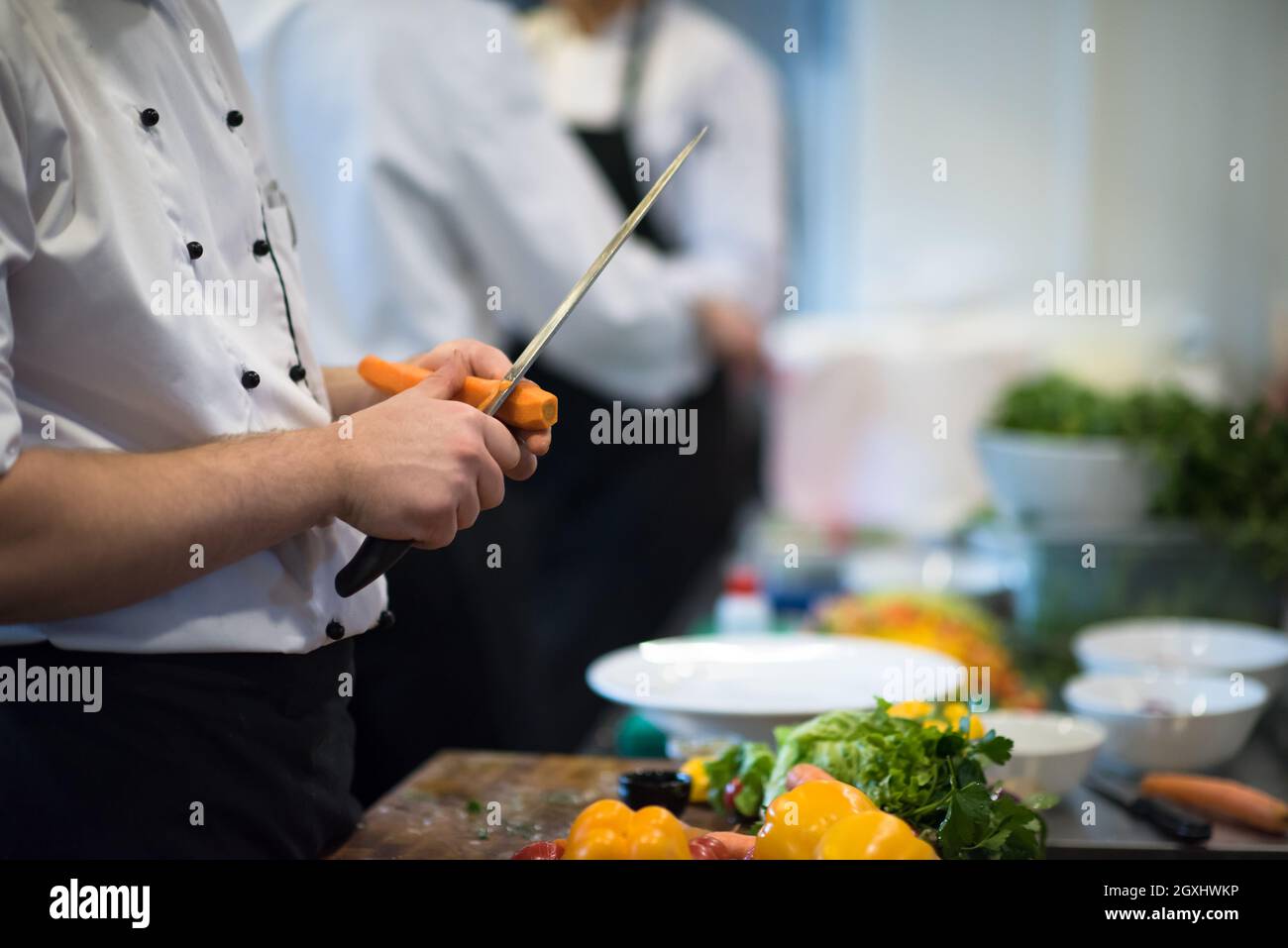 chef hands cutting carrots on a wooden table preparation for meal at ...