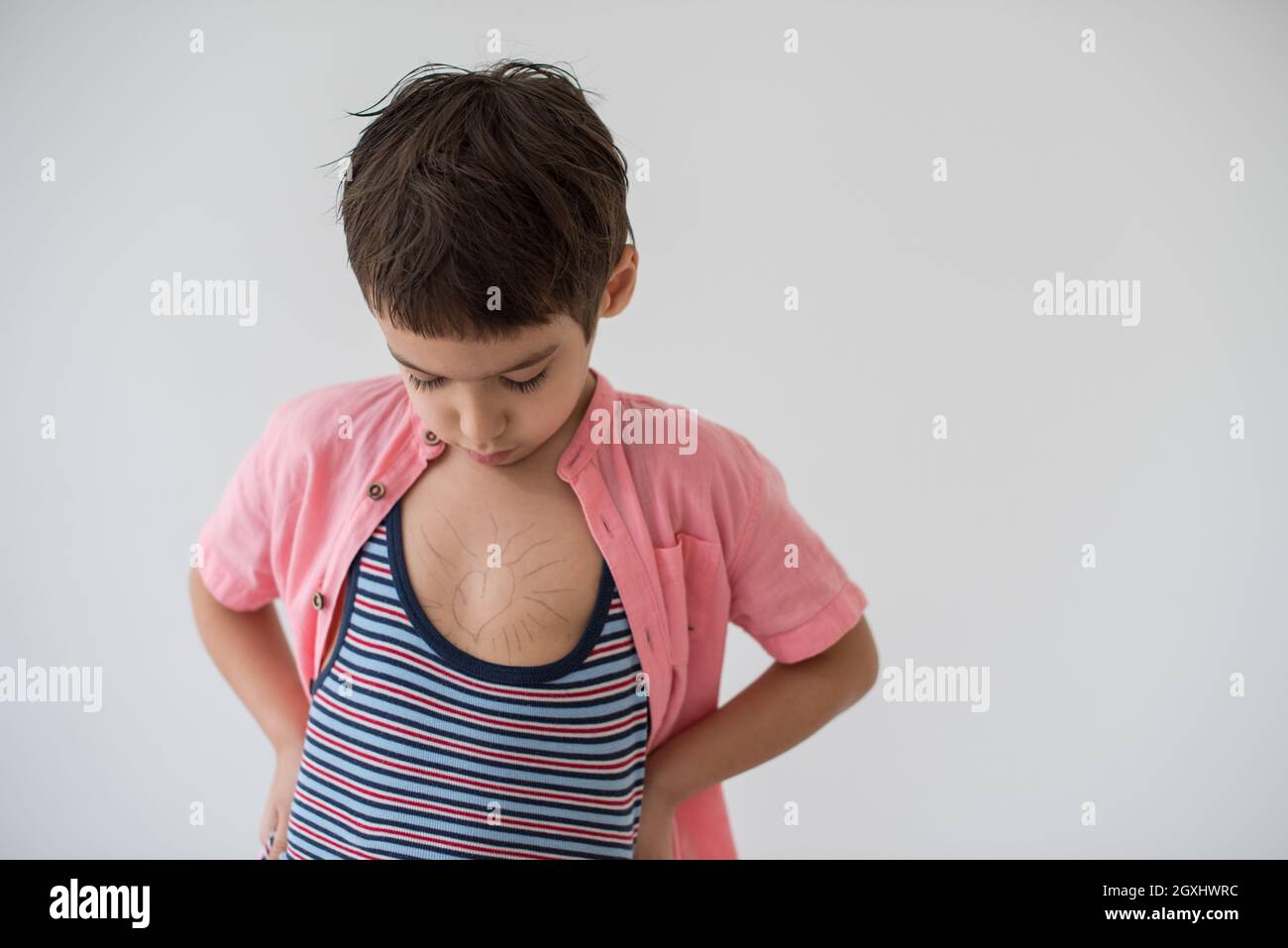 happy little boy looking at heart love symbol sketched on his chest ...