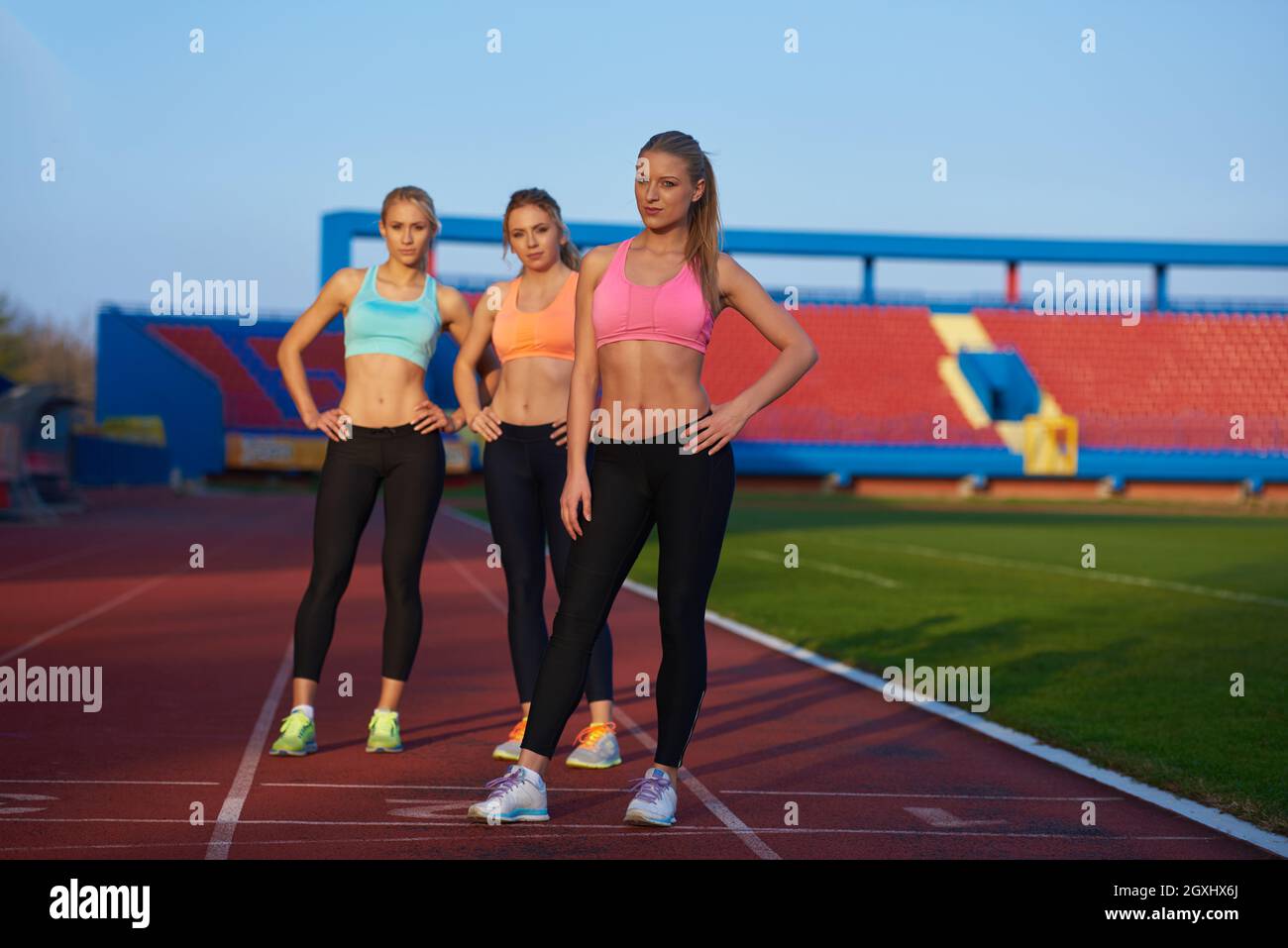 athlete woman group running on athletics race track on soccer stadium ...
