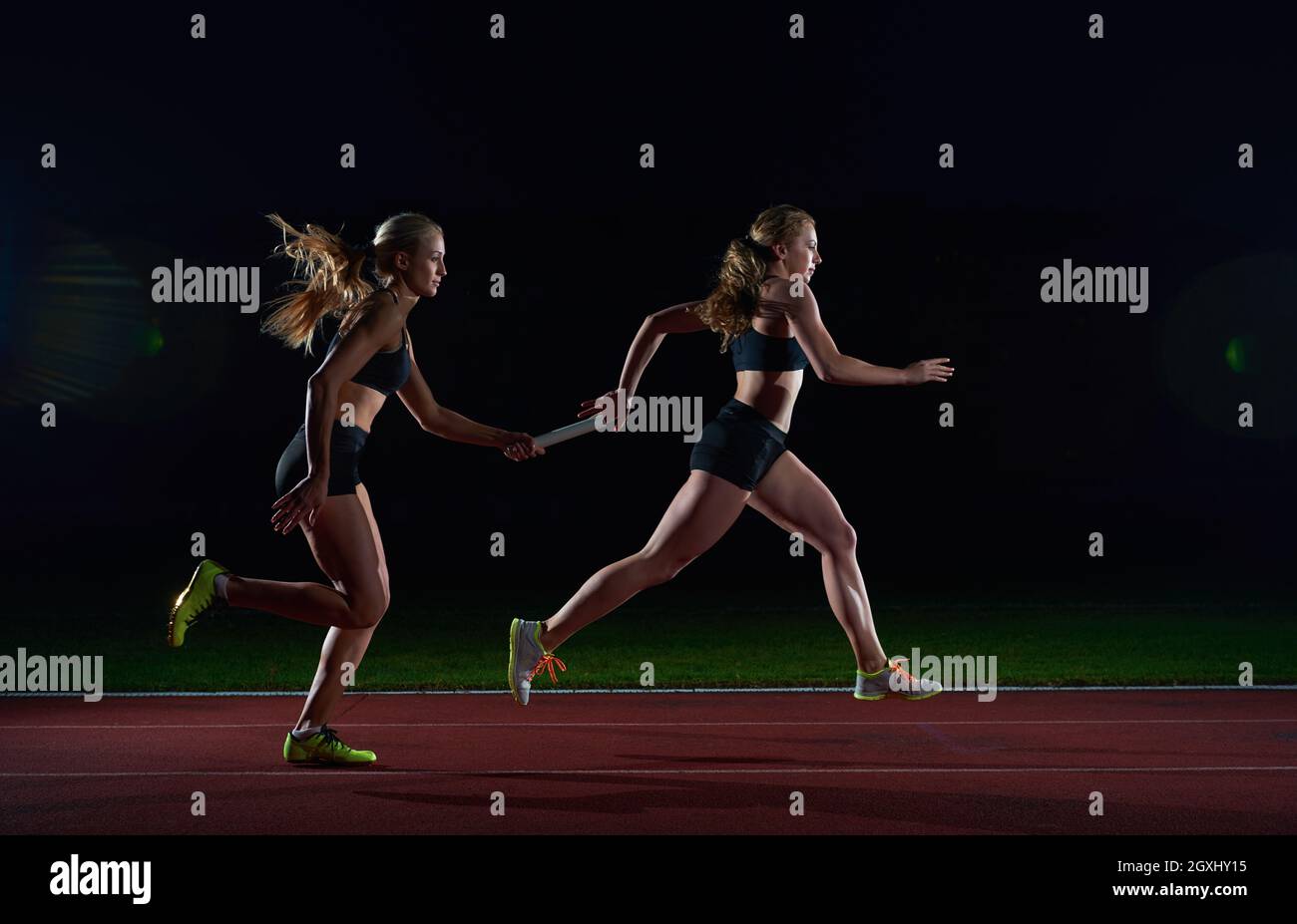 woman athletic runners passing baton in relay race Stock Photo - Alamy