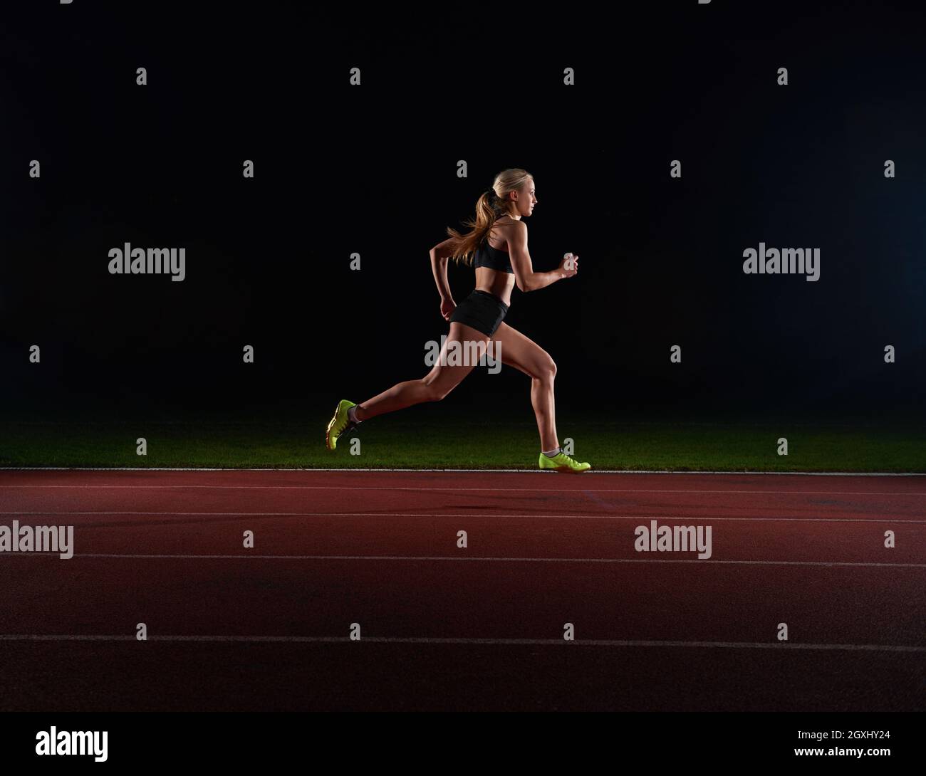 Athletic woman running onrace track Stock Photo - Alamy