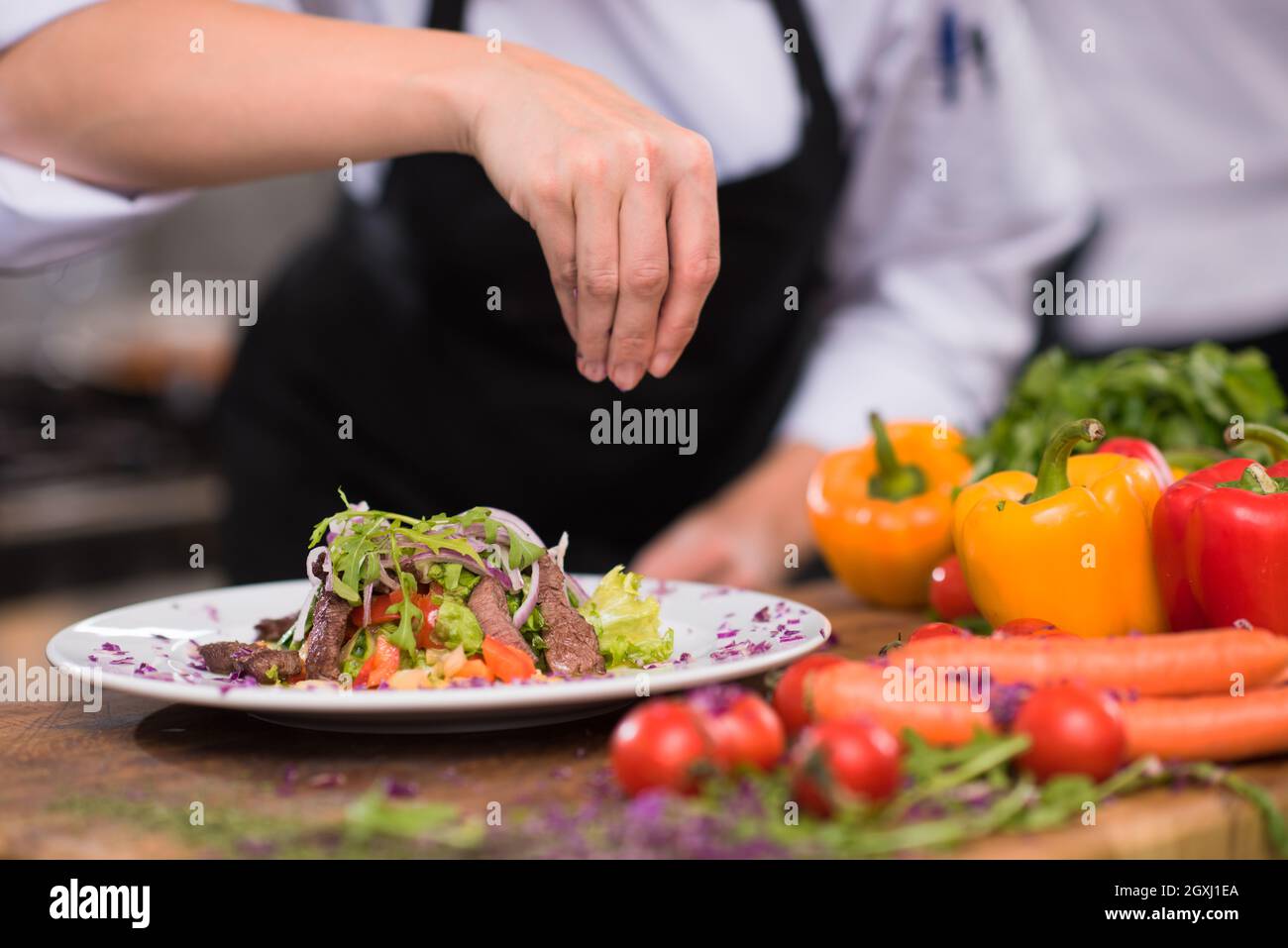 cook chef decorating garnishing prepared meal dish on the plate in ...
