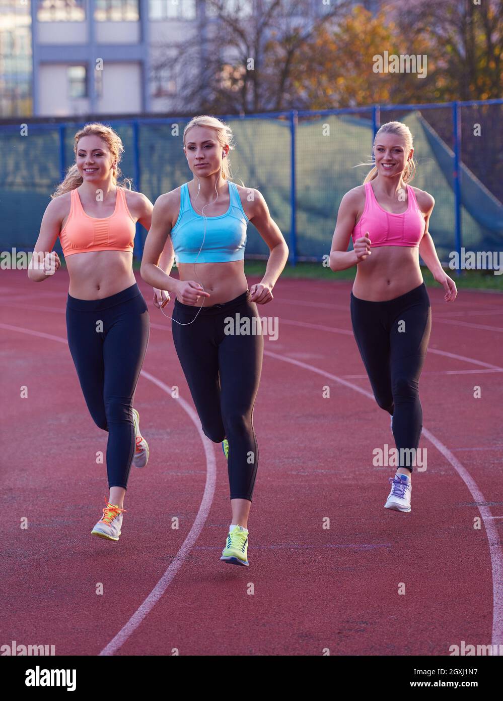 athlete woman group running on athletics race track on soccer stadium ...