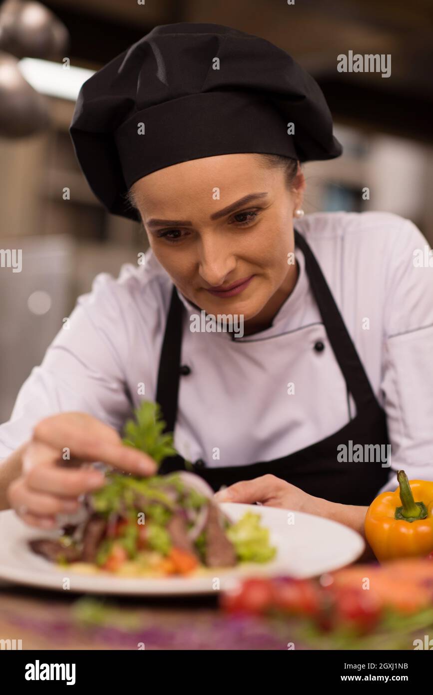 cook chef decorating garnishing prepared meal dish on the plate in ...