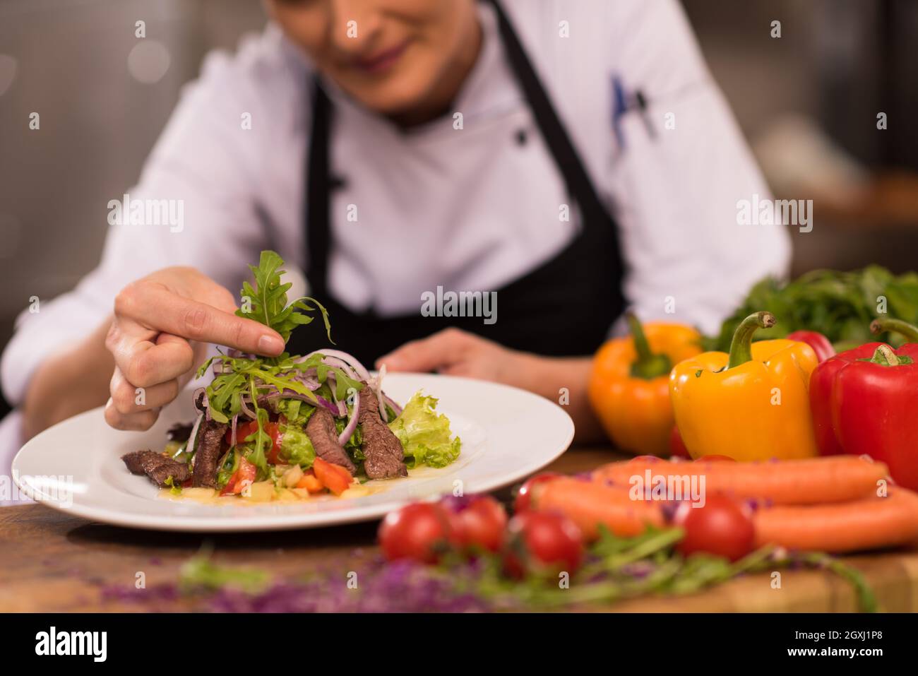 cook chef decorating garnishing prepared meal dish on the plate in ...