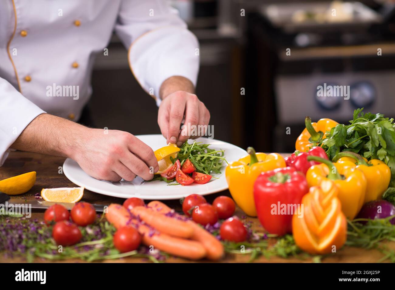 chef serving vegetable salad on plate in restaurant kitchen Stock Photo ...
