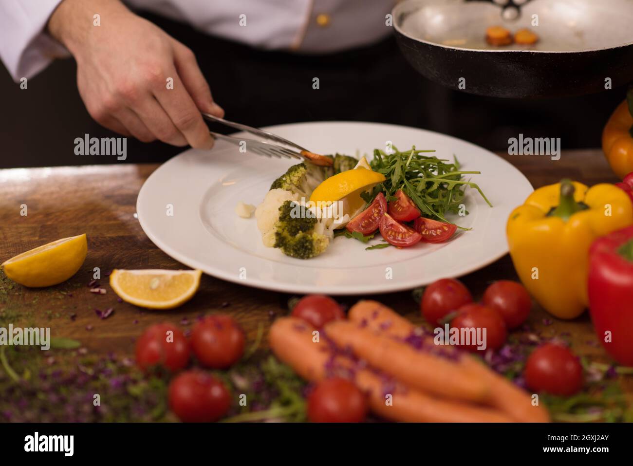 chef serving vegetable salad on plate in restaurant kitchen Stock Photo ...