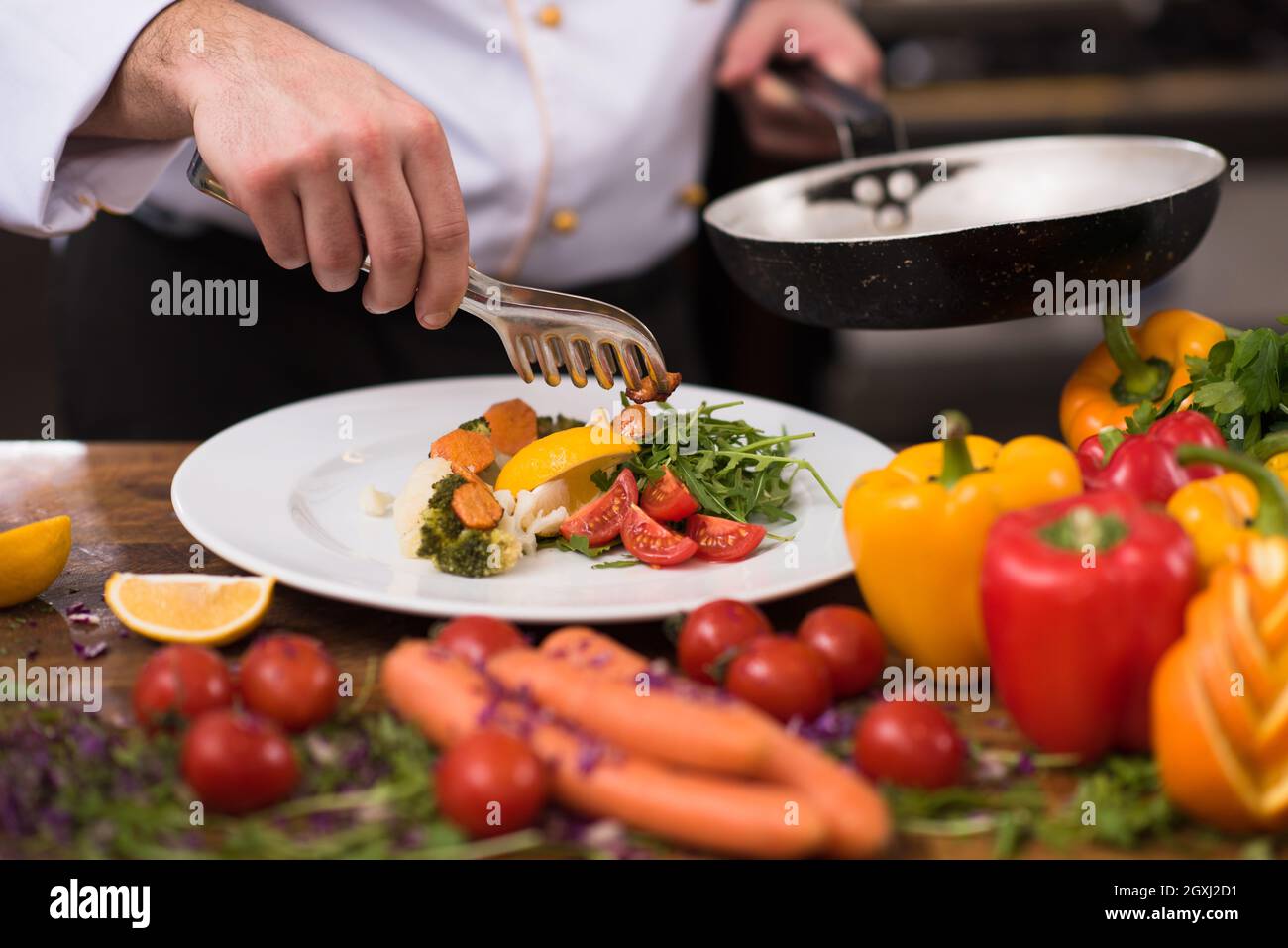 chef serving vegetable salad on plate in restaurant kitchen Stock Photo ...
