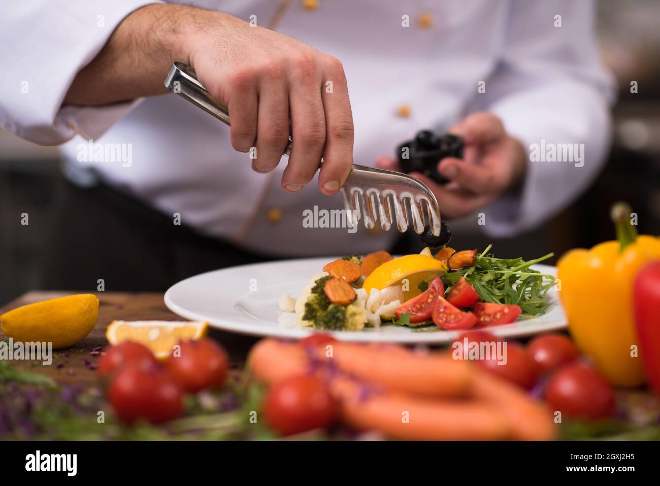 chef serving vegetable salad on plate in restaurant kitchen Stock Photo ...