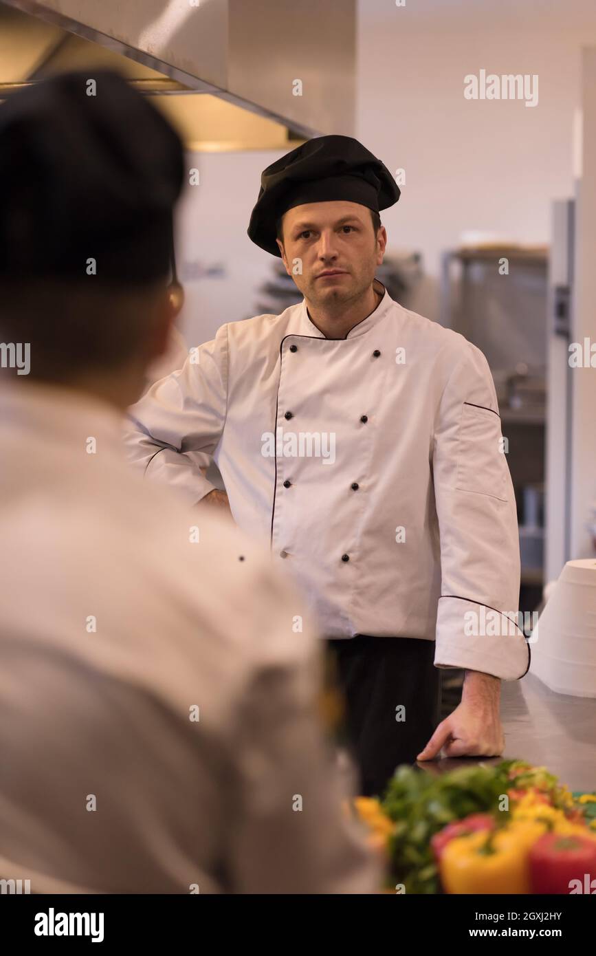 Portrait of young chef standing in commercial kitchen at restaurant ...
