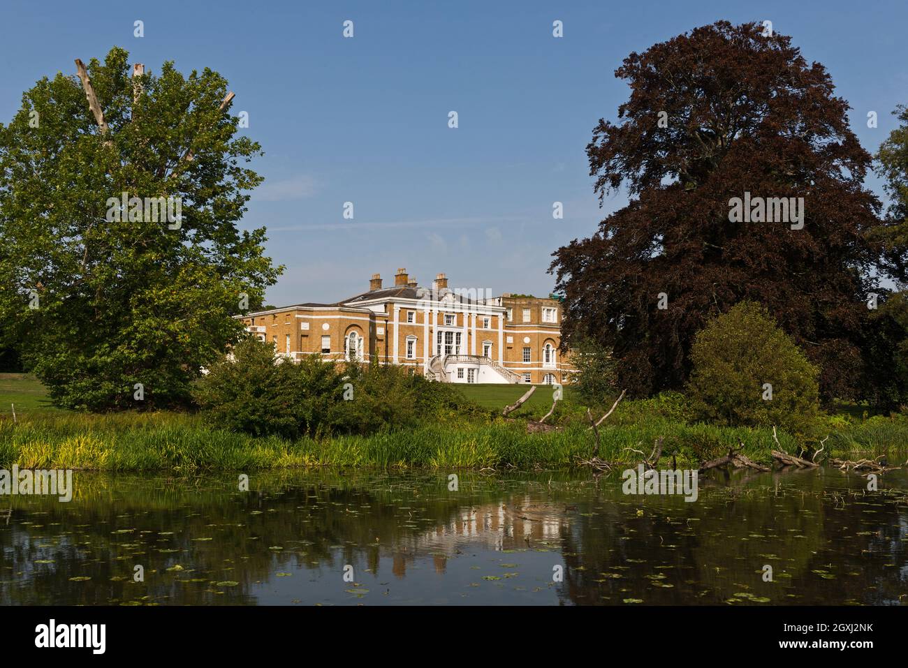 Summertime view across the Serpentine lake at Waverley Abbey House ...