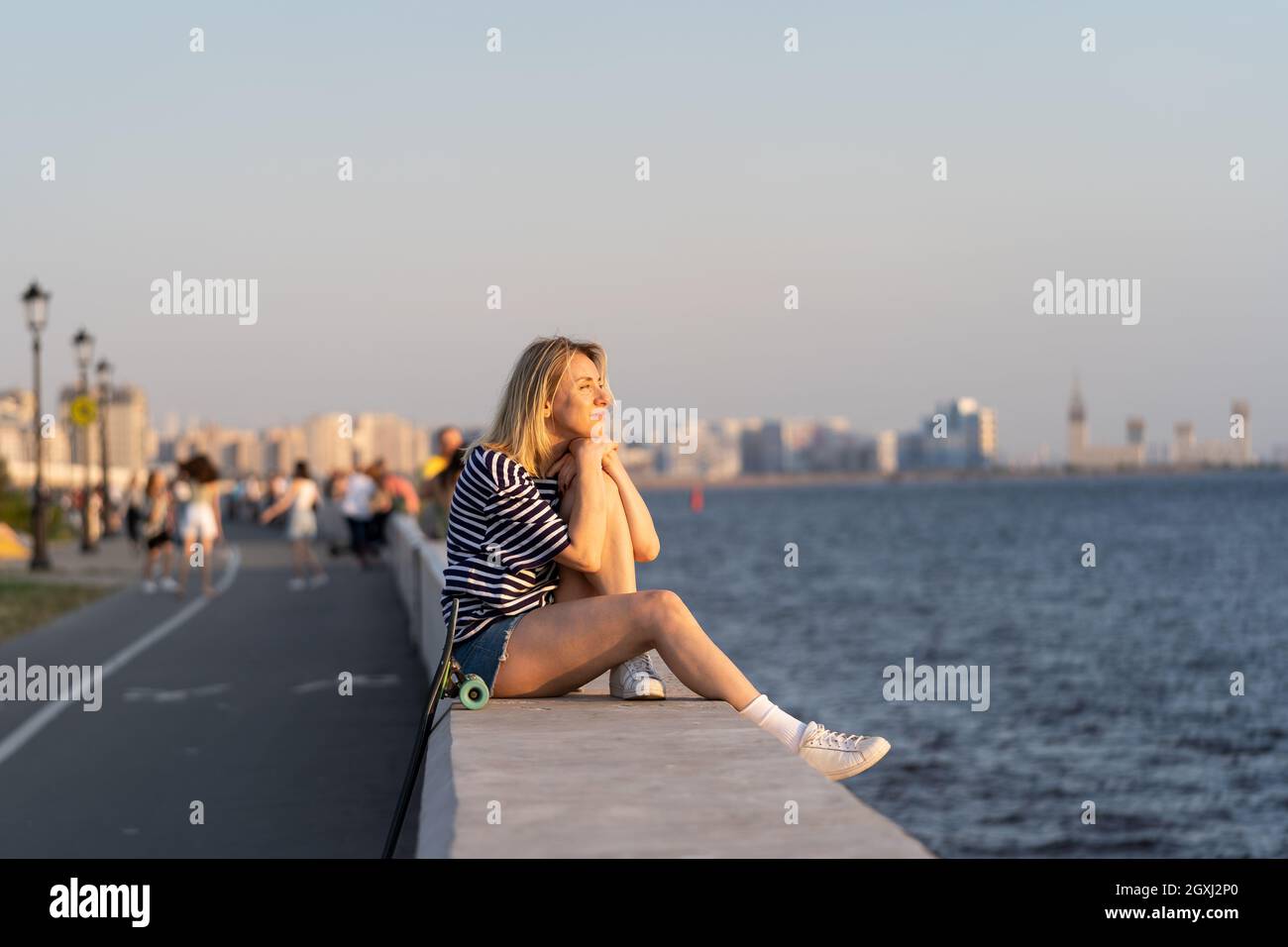 In harmony with yourself: woman in 40s sit alone on river bank enjoy ...