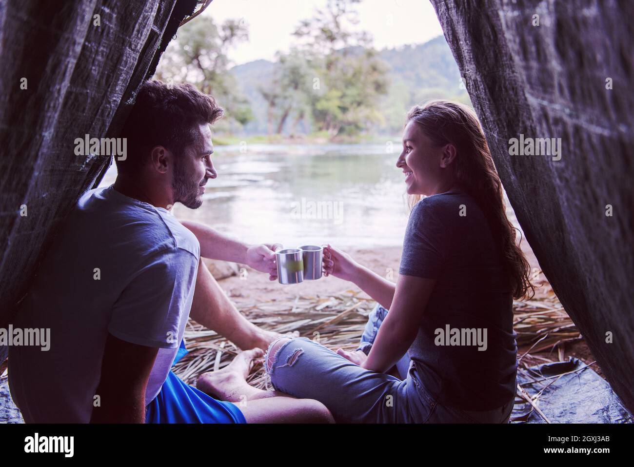 couple in love traveling and spending time together in straw tent while ...