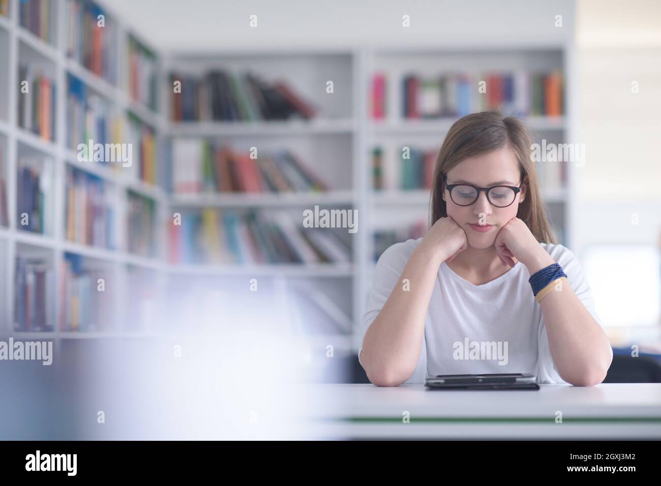 female student study in school library, using tablet and searching for ...