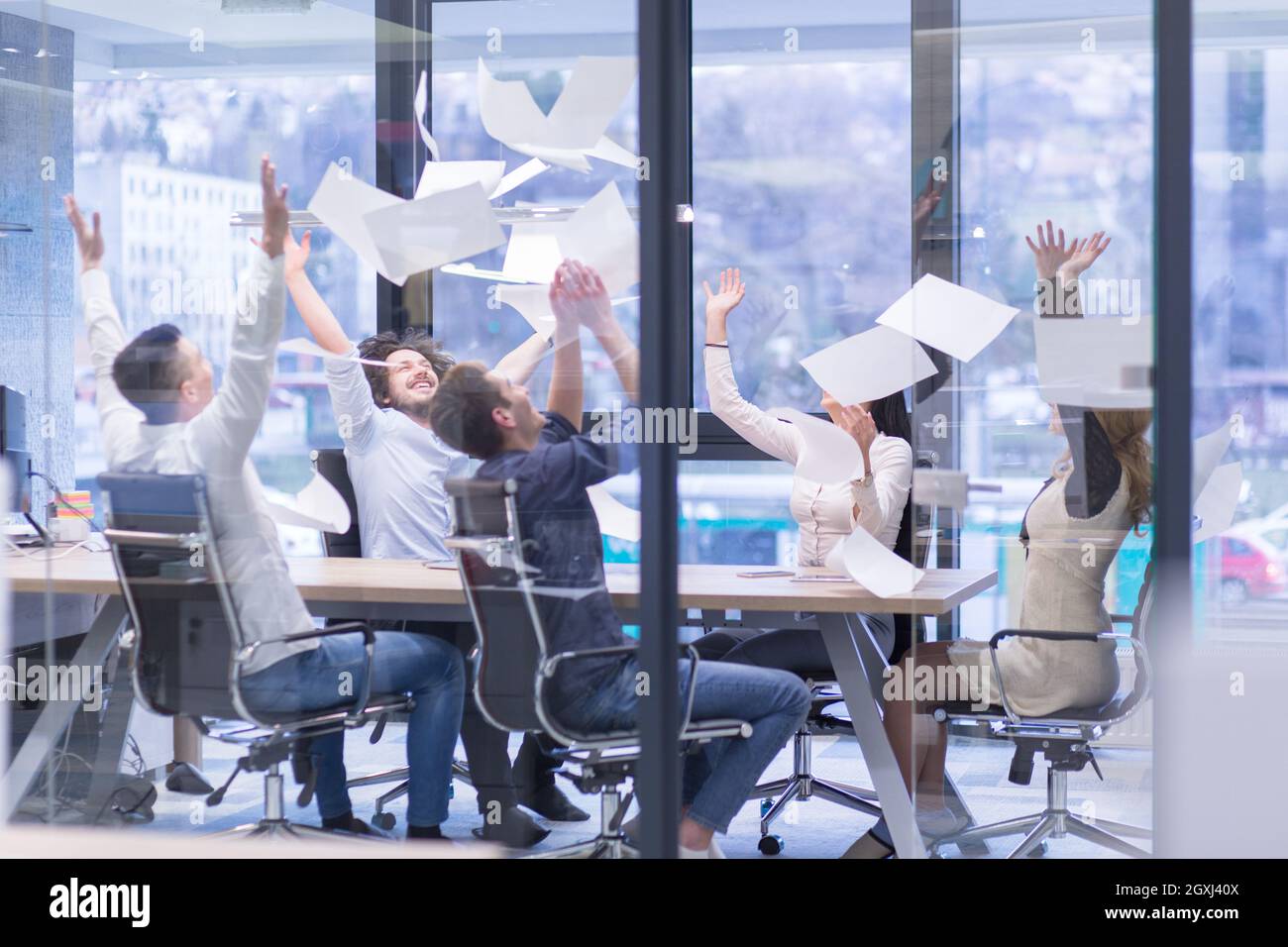 Group of young business people throwing documents and looking happy ...
