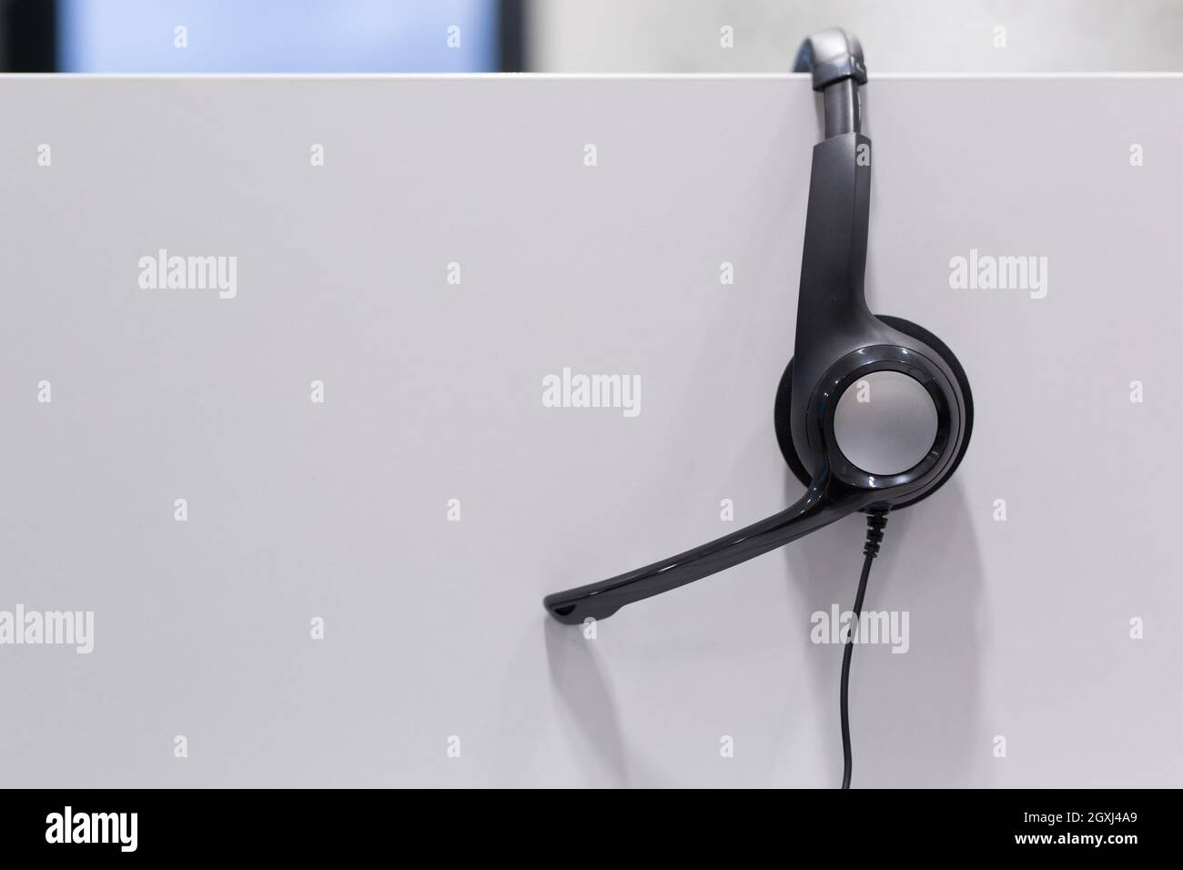 Headphones hanging on cubicle partition in empty call center office ...