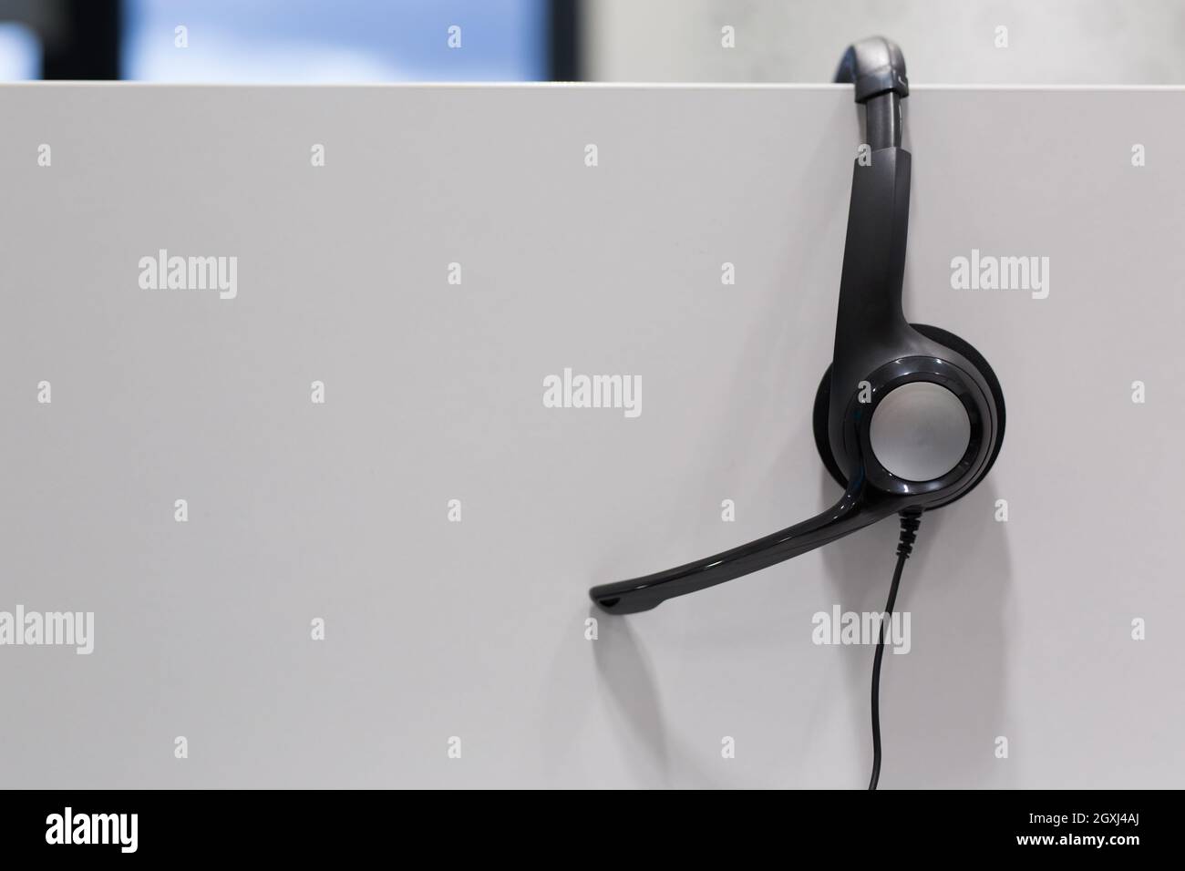Headphones hanging on cubicle partition in empty call center office ...