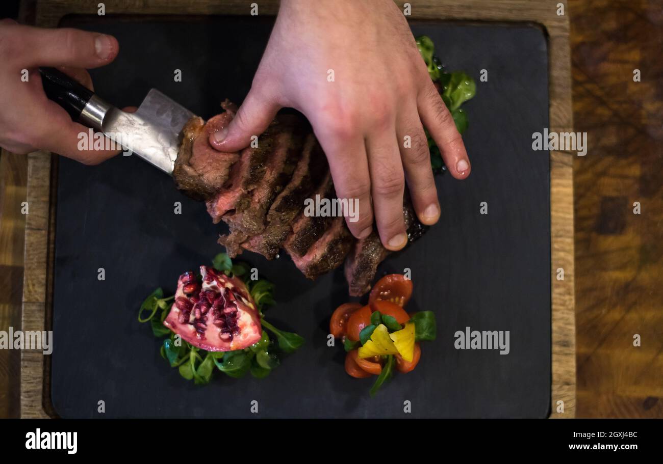 top view of Chef hands in hotel or restaurant kitchen serving beef ...