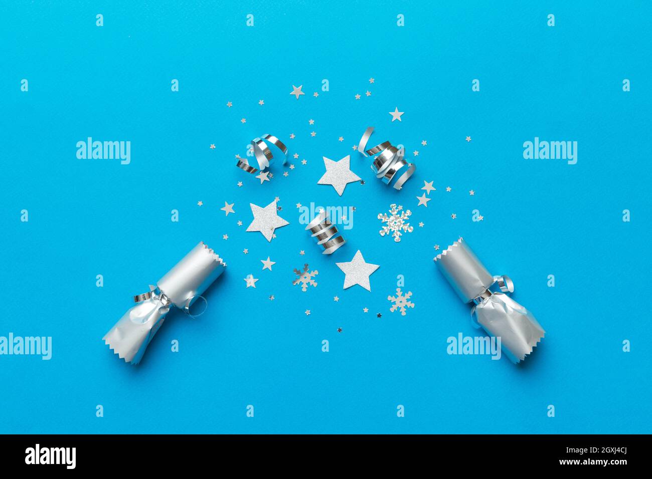 Christmas crackers with shiny confetti on color background, top view ...