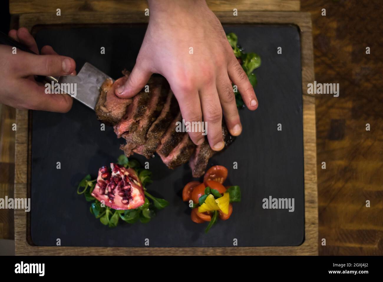 top view of Chef hands in hotel or restaurant kitchen serving beef ...