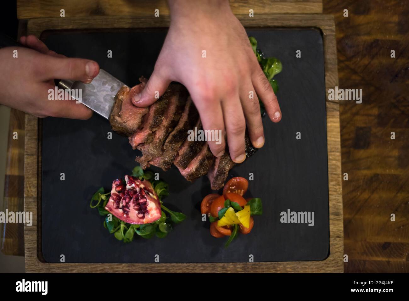 top view of Chef hands in hotel or restaurant kitchen serving beef ...