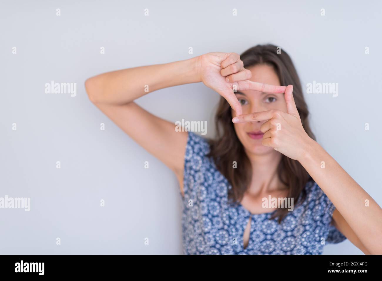young happy woman showing framing hand gesture isolated on a white ...