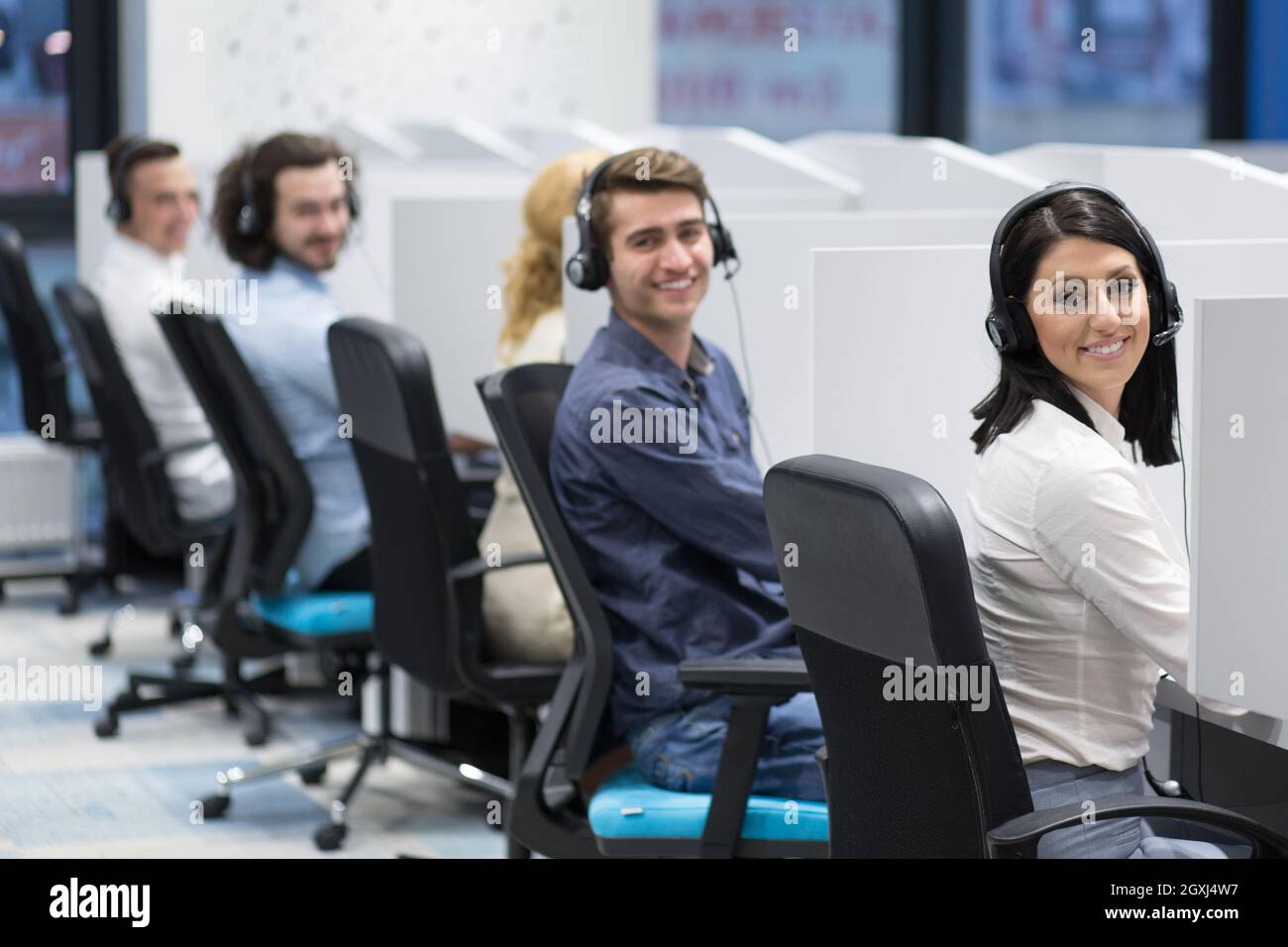 group of young business people with headset working and giving support ...