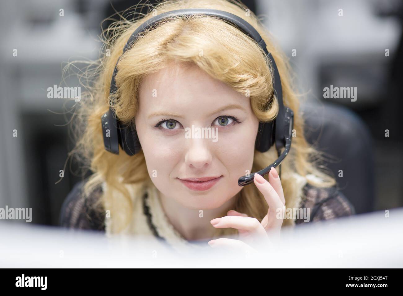 young smiling female call centre operator doing her job with a headset Stock Photo - Alamy